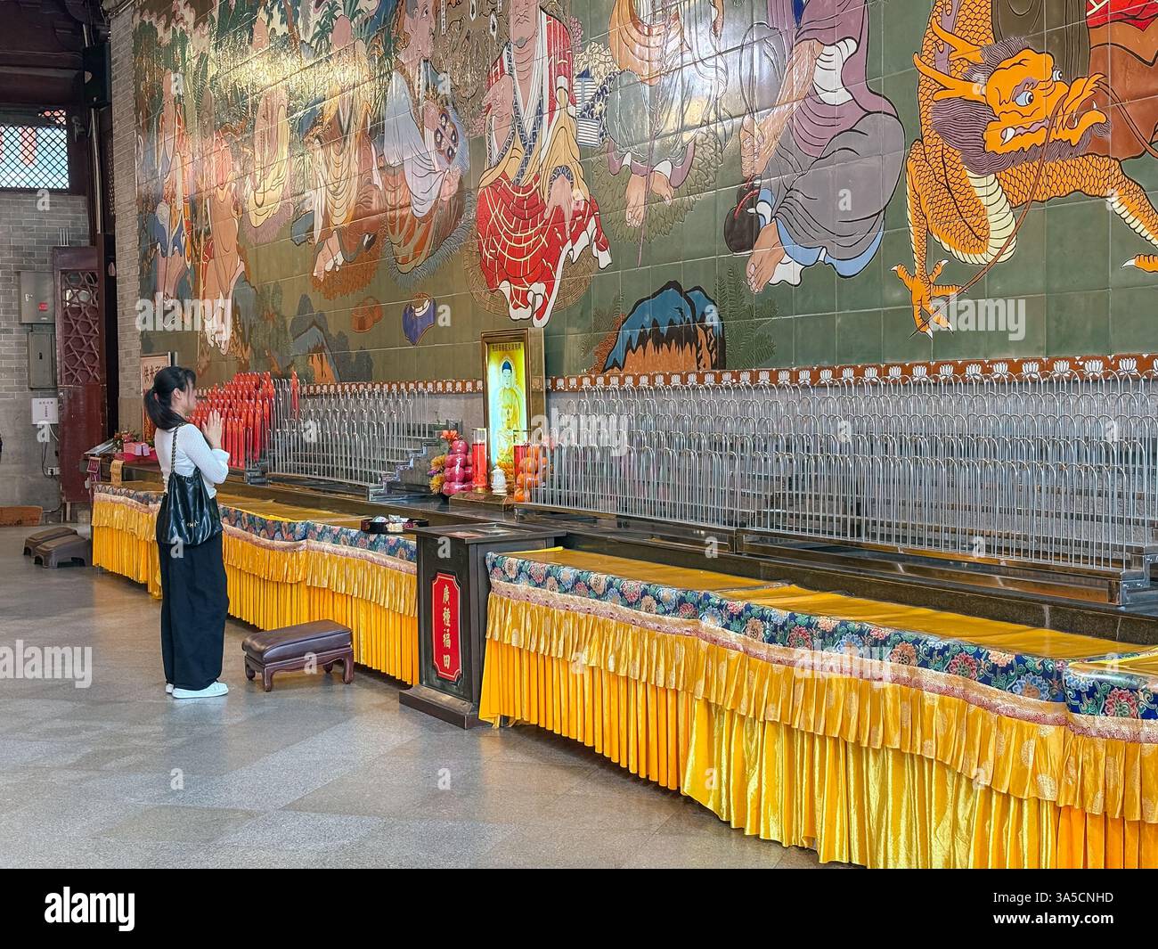 Woman praying at an altar in a Buddhist temple in Guangzhou, China ...