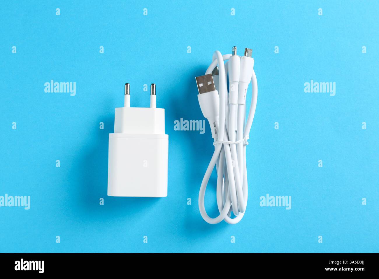 USB power adapter and triple charge cable on light blue background ...
