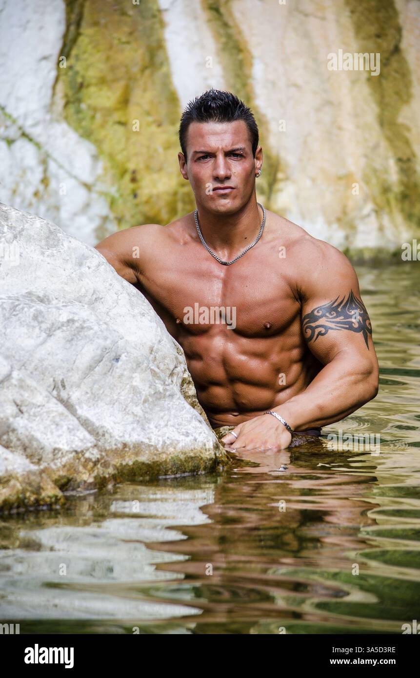 Handsome young muscle man standing in water pond or river Stock Photo ...