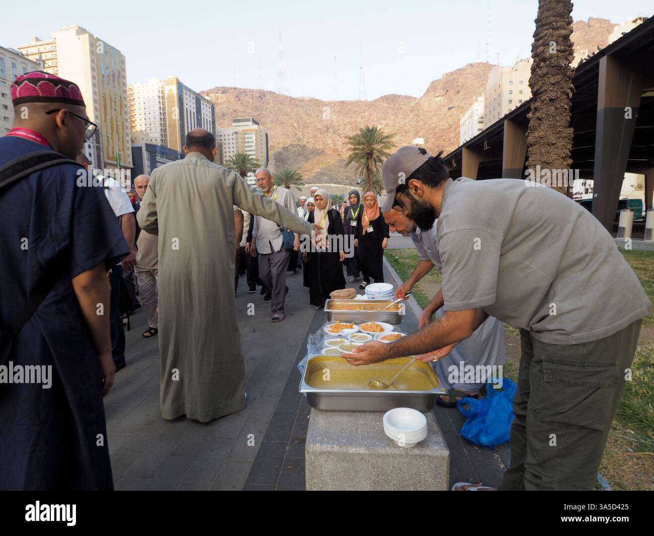 Distributing free food on street in Mecca, Saudi Arabia Stock Photo - Alamy