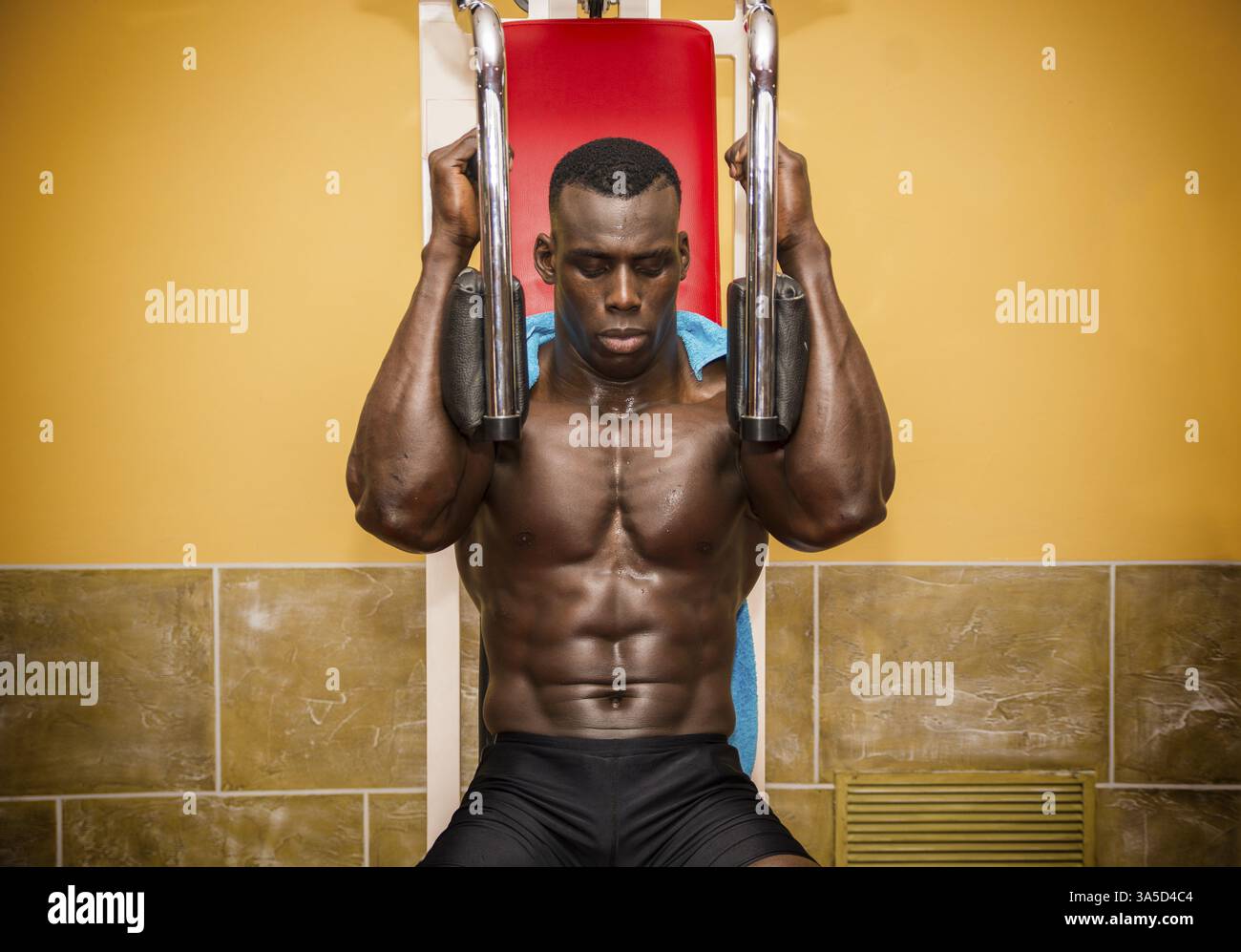 Hunky muscular black bodybuilder working out in gym, exercising pecs on ...