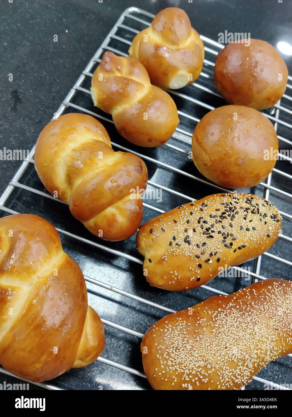 Various types of golden brown baked goods cool on a wire rack ...
