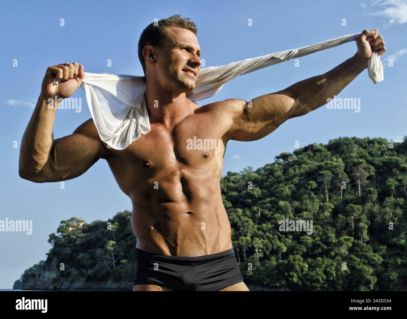 Attractive and muscular smiling bodybuilder outdoors, in nature ...