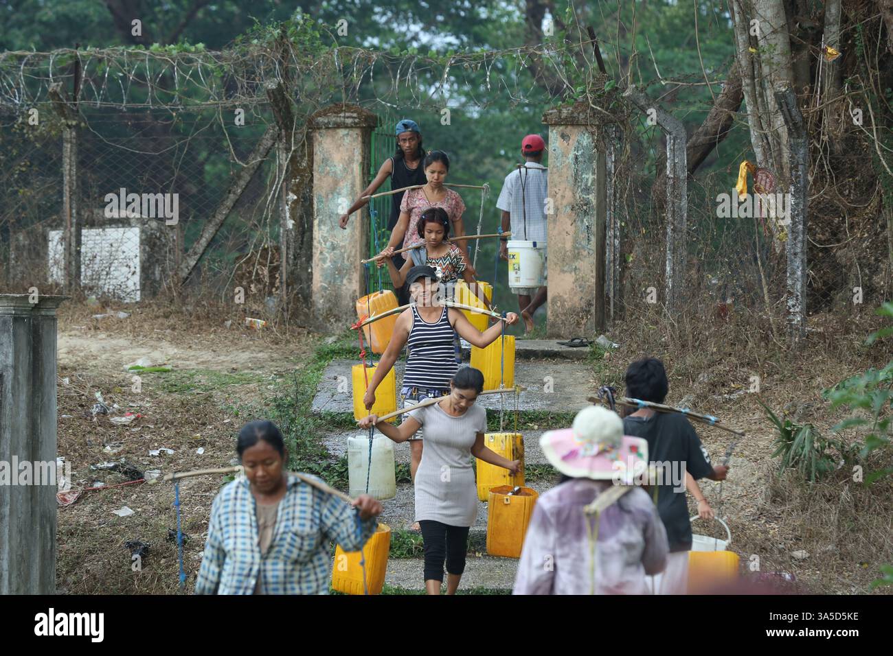 Yangon, Myanmar. 22nd Mar, 2025. Residents carry water from a lake at ...