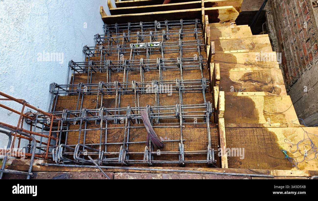Steel reinforcement bars are arranged on wooden supports at a ...