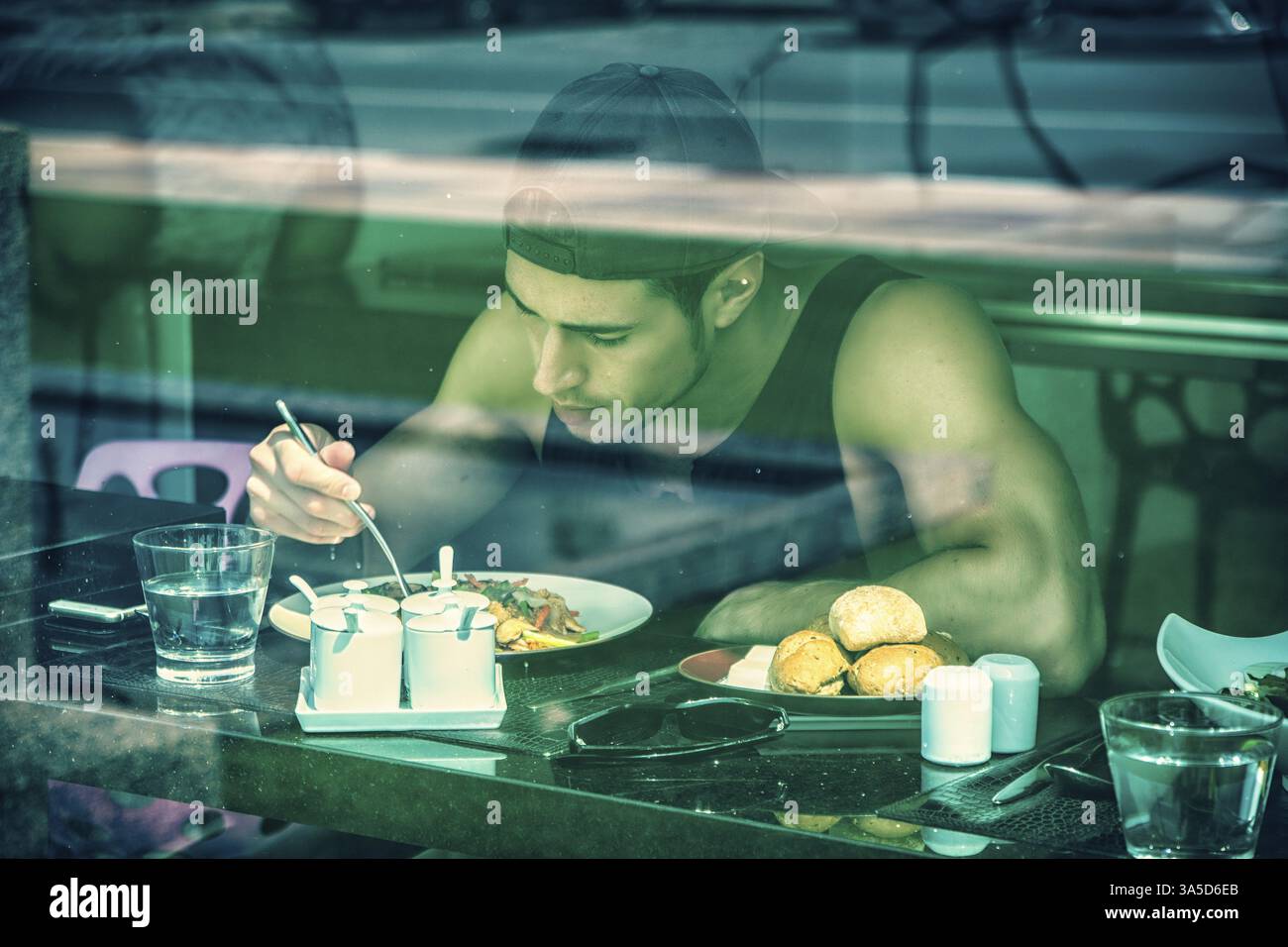 Shot through glass of man having meal in cafe Stock Photo - Alamy