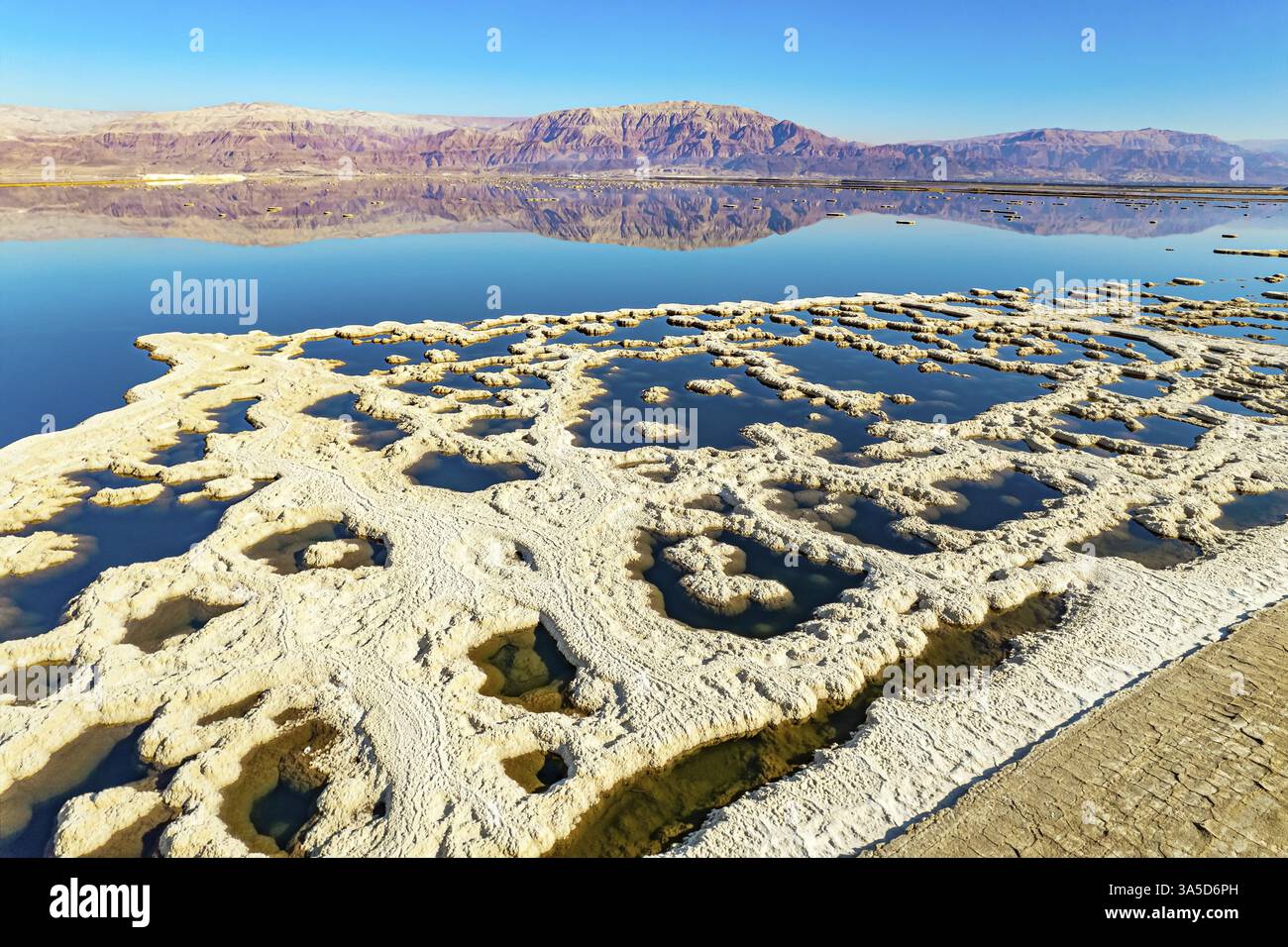 Evaporated salt forms bizarre patterns on the water. Dead Sea. The blue ...