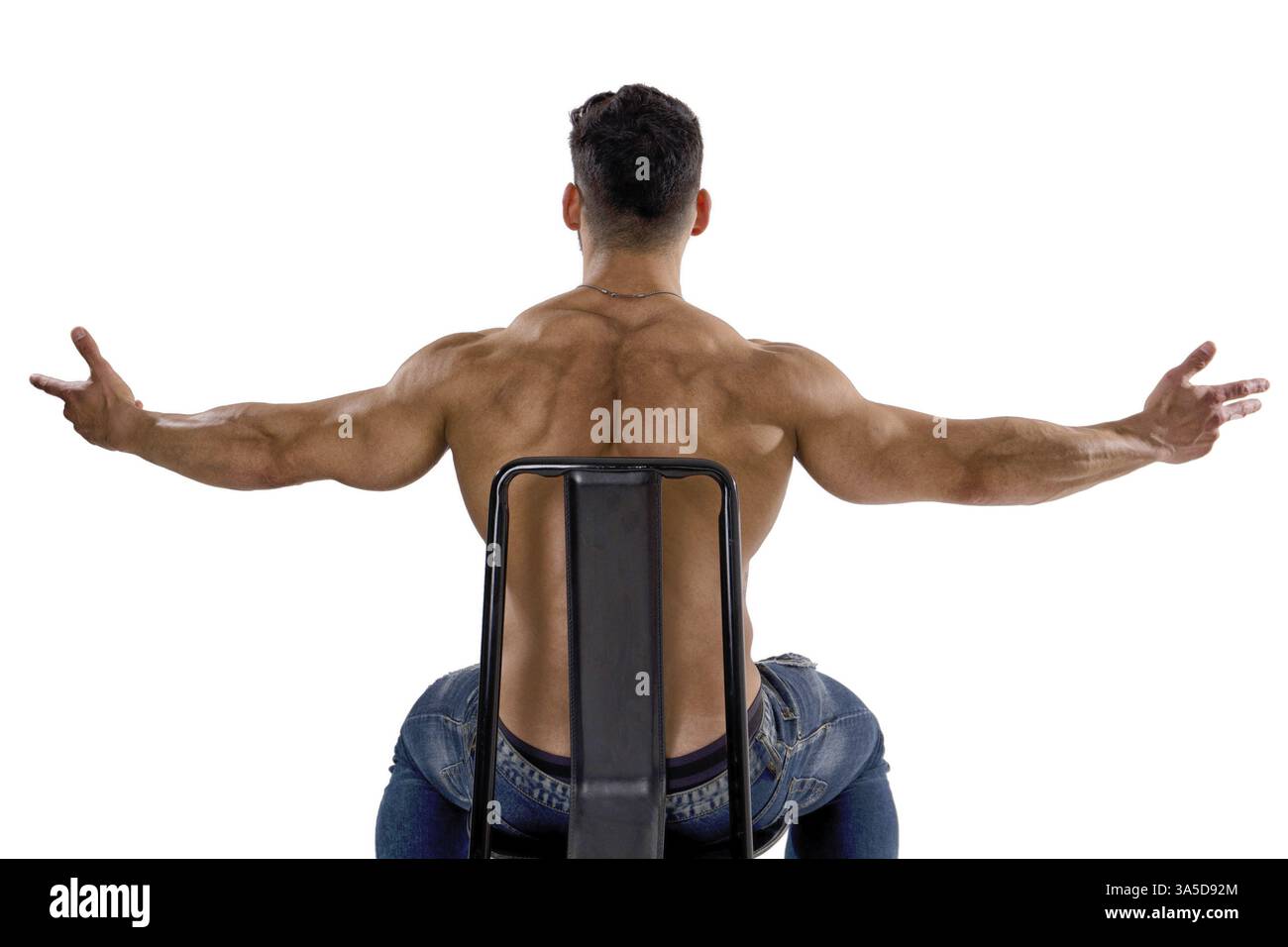 Male bodybuilder sitting on chair, seen from behind, unrecognizable man ...