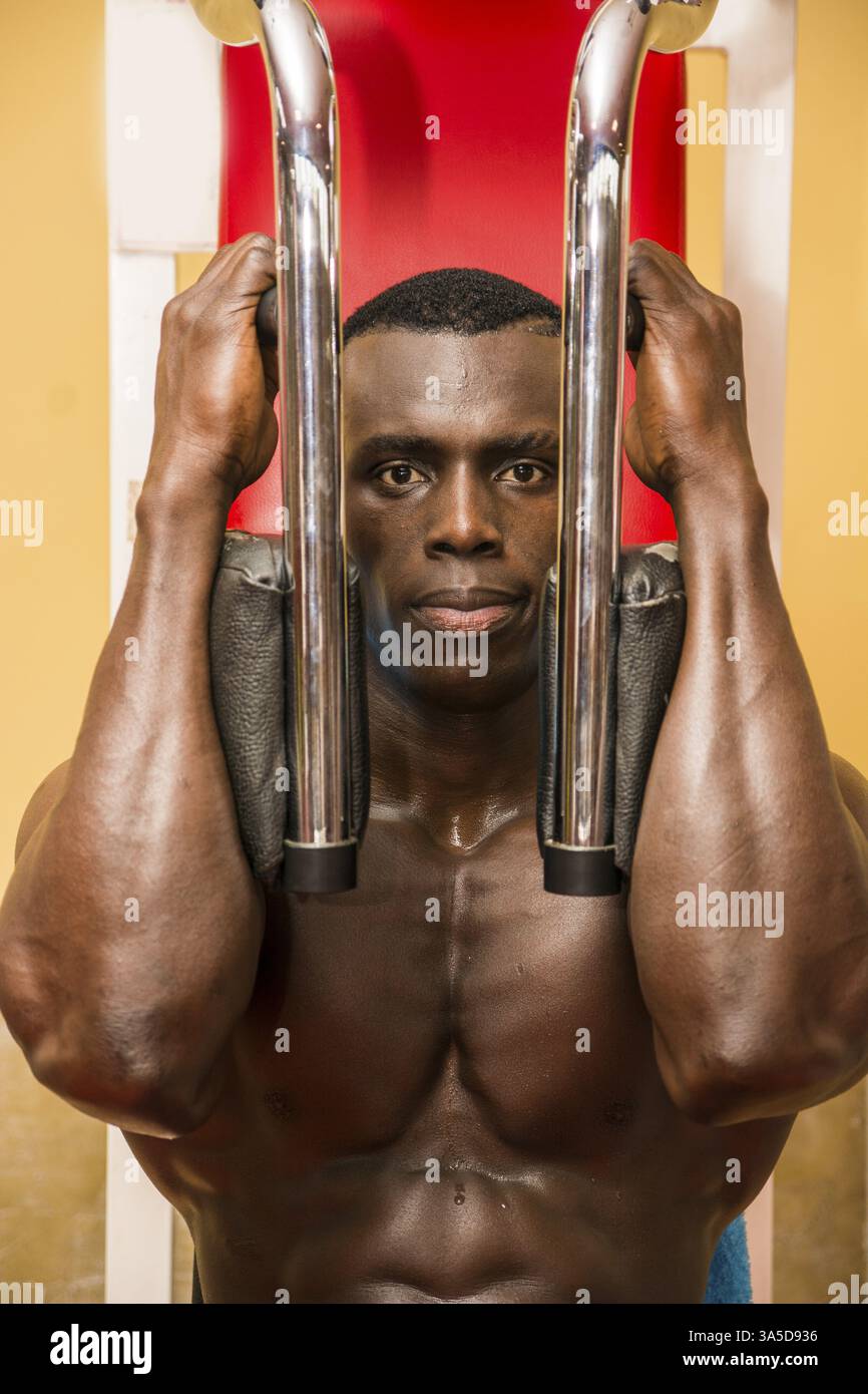 Hunky muscular black bodybuilder working out in gym, exercising pecs on ...