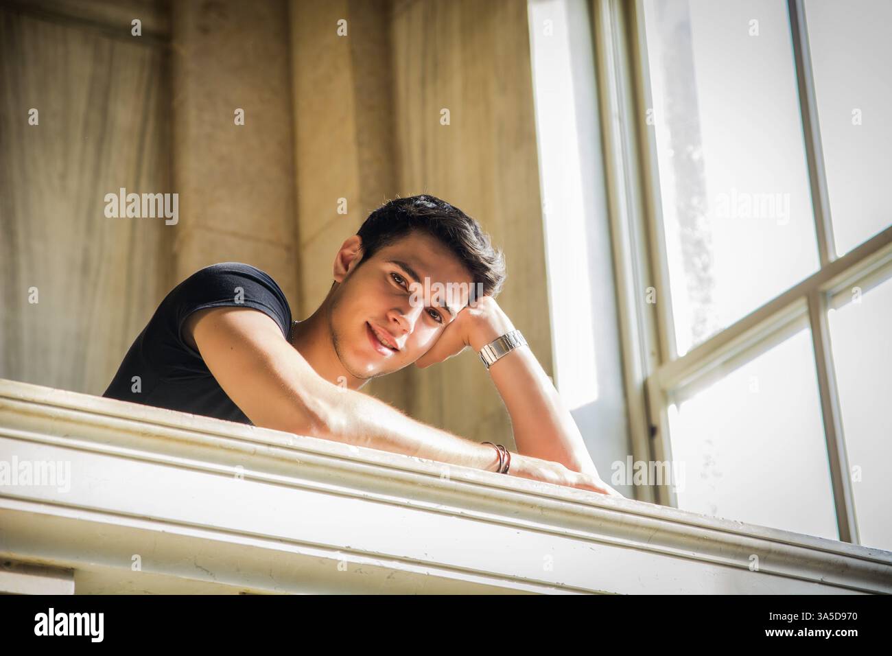 Portrait of Smiling Attractive Young Man Leaning on Folded Arms Against ...