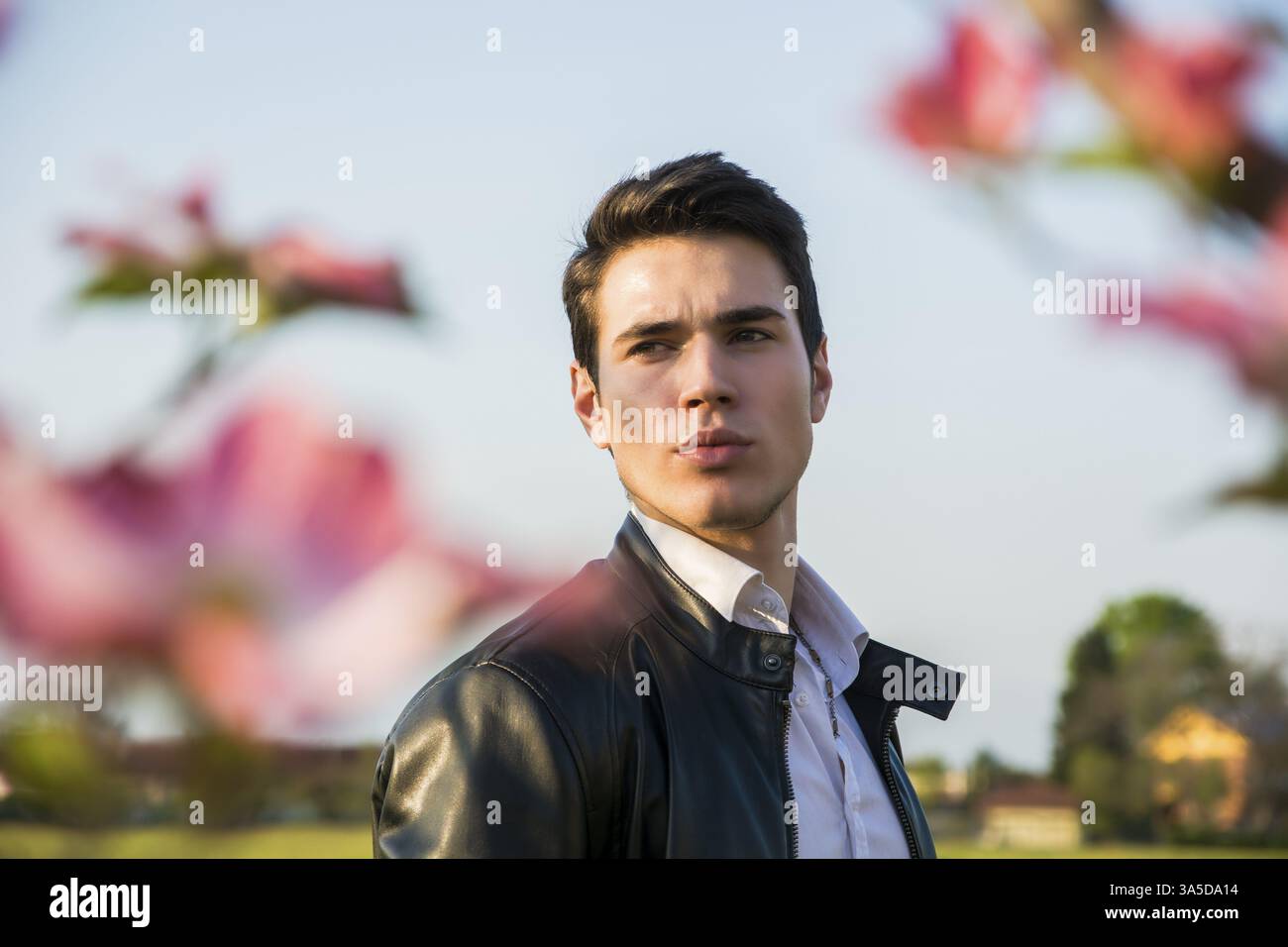 Good looking male model at couuntryside, among flowers, enjoying nature ...