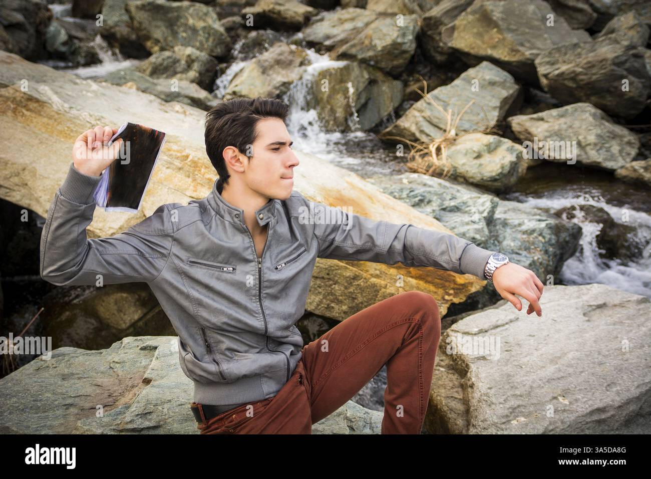 Handsome Young Man on Big Rocks at the River Throwing Something at the ...