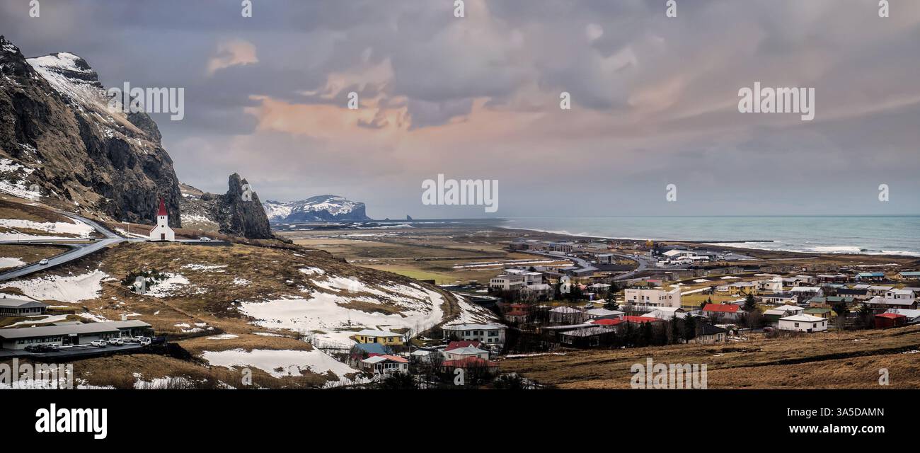 An aerial view of a chapel on top of a hill over Vik, Iceland in the ...