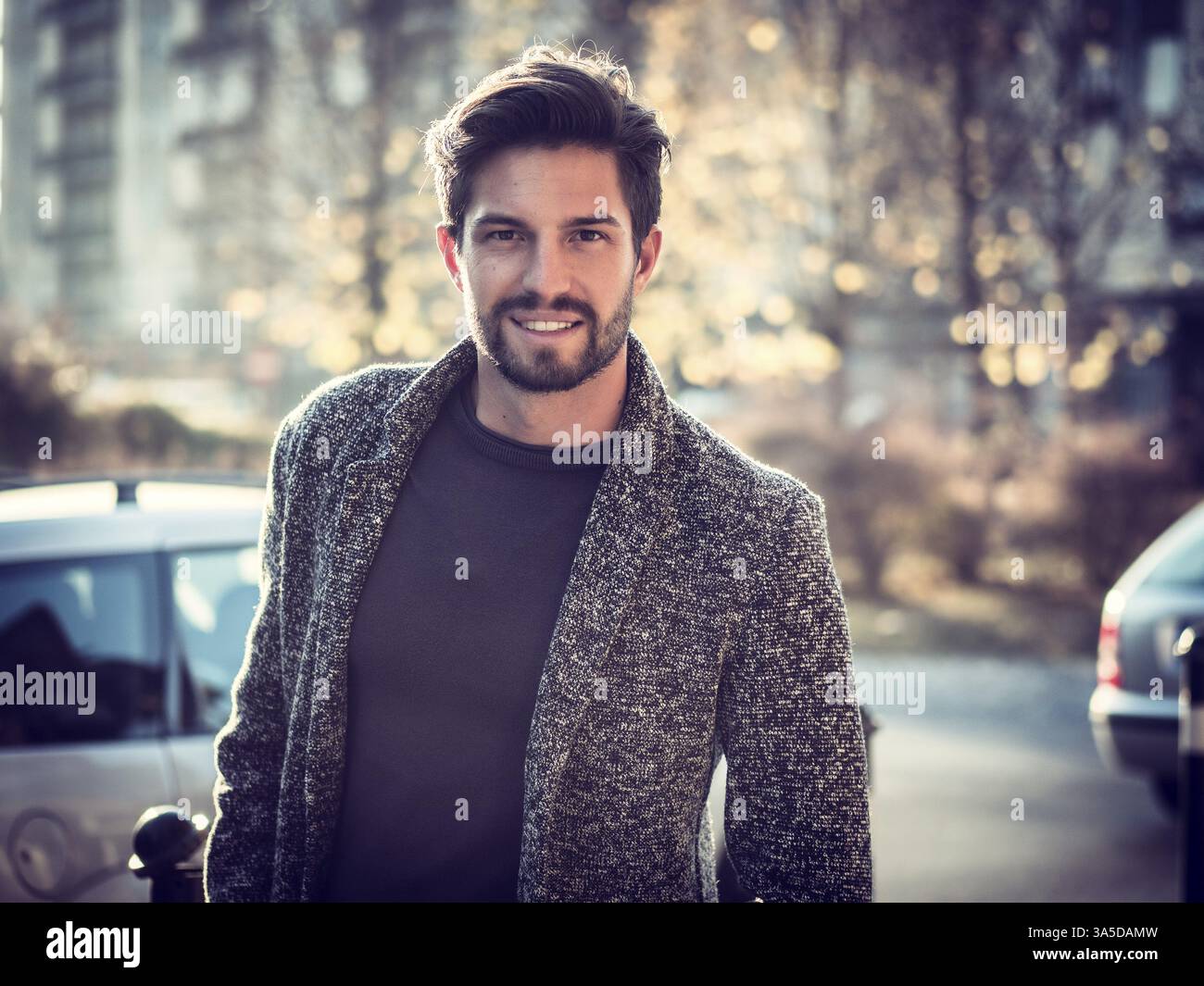 One handsome young man in urban setting in European city, standing ...