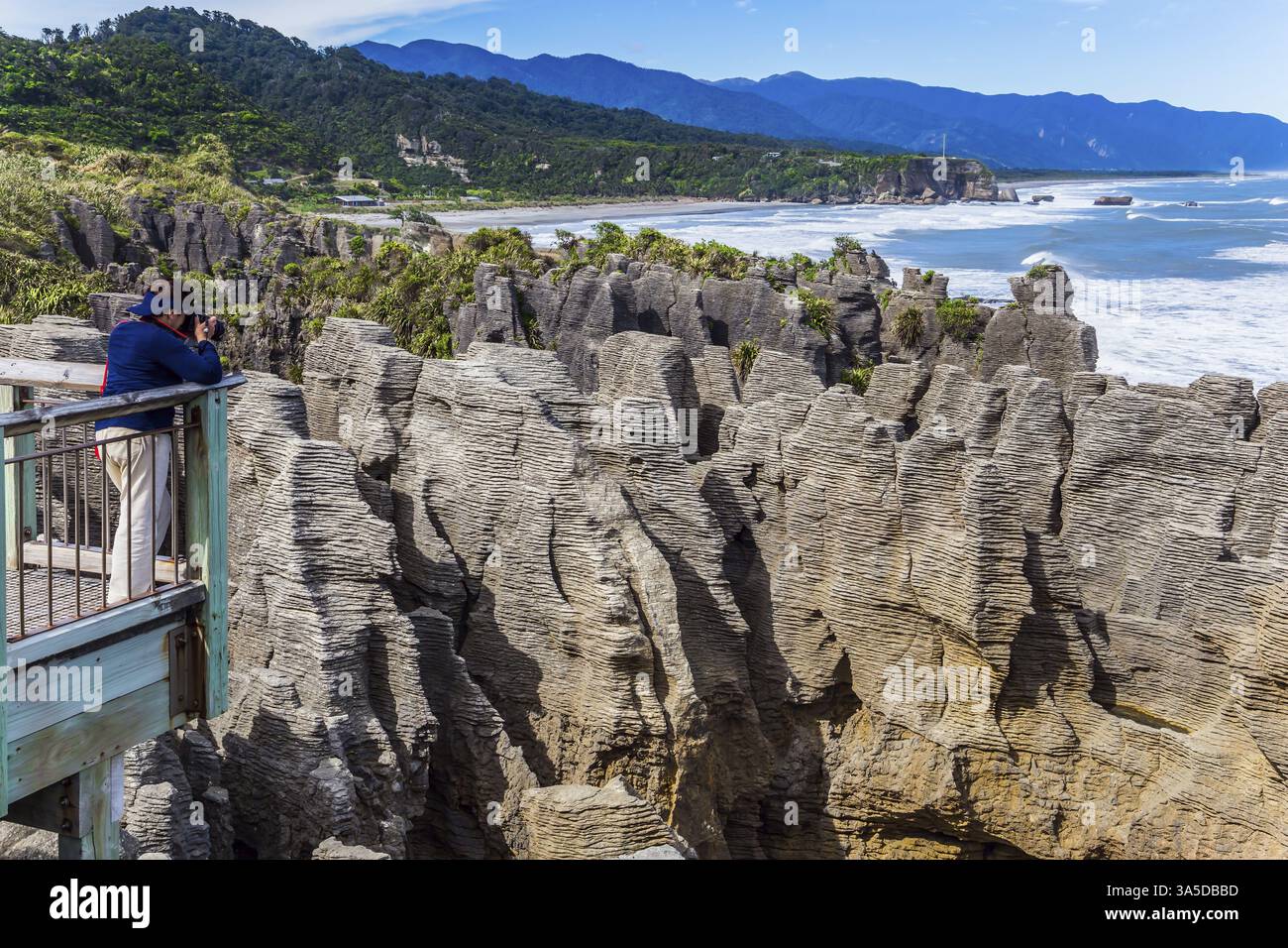 Observation deck. Woman takes pictures of rocks and ocean surf. New ...