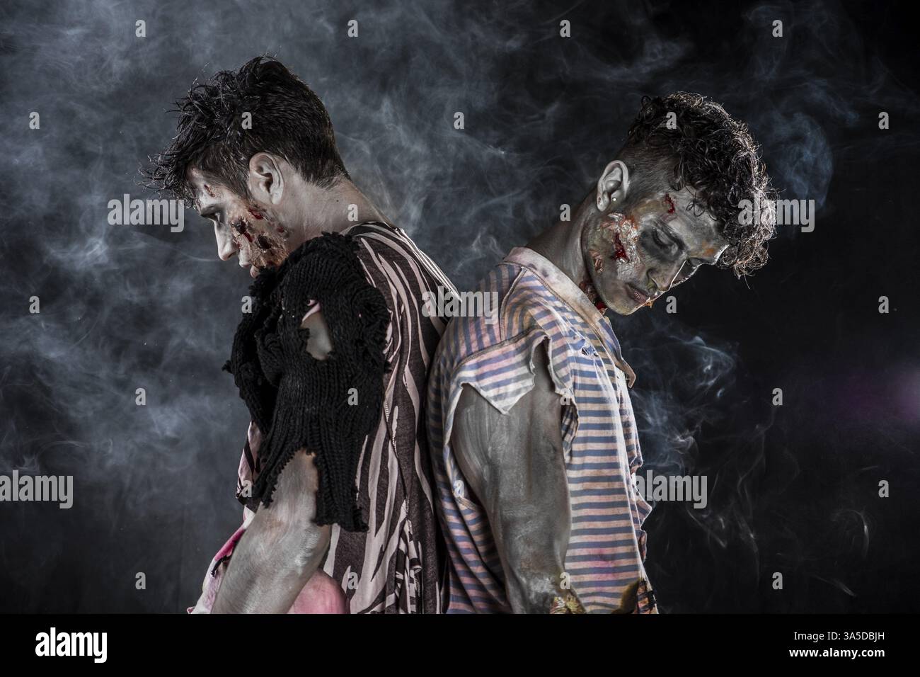Two male zombies standing on black smoky background, head and shoulder ...