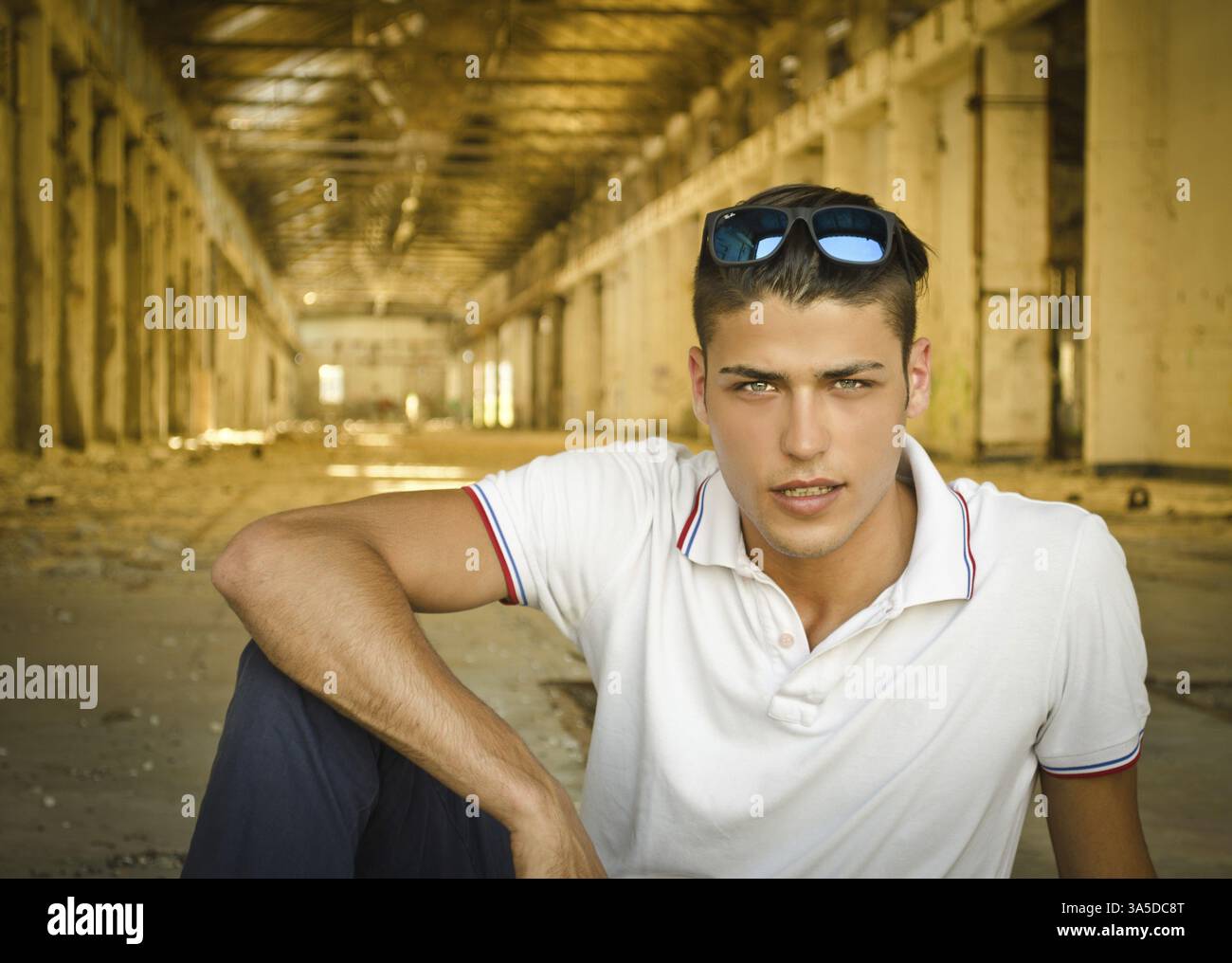 Handsome young man in abandoned, empty warehouse or old factory Stock ...