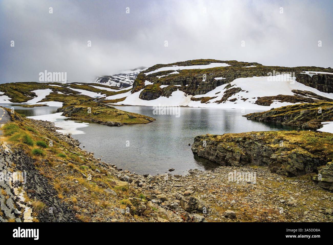 Gorgeous Snow Road in Norway. The cold water of the lake is covered ...