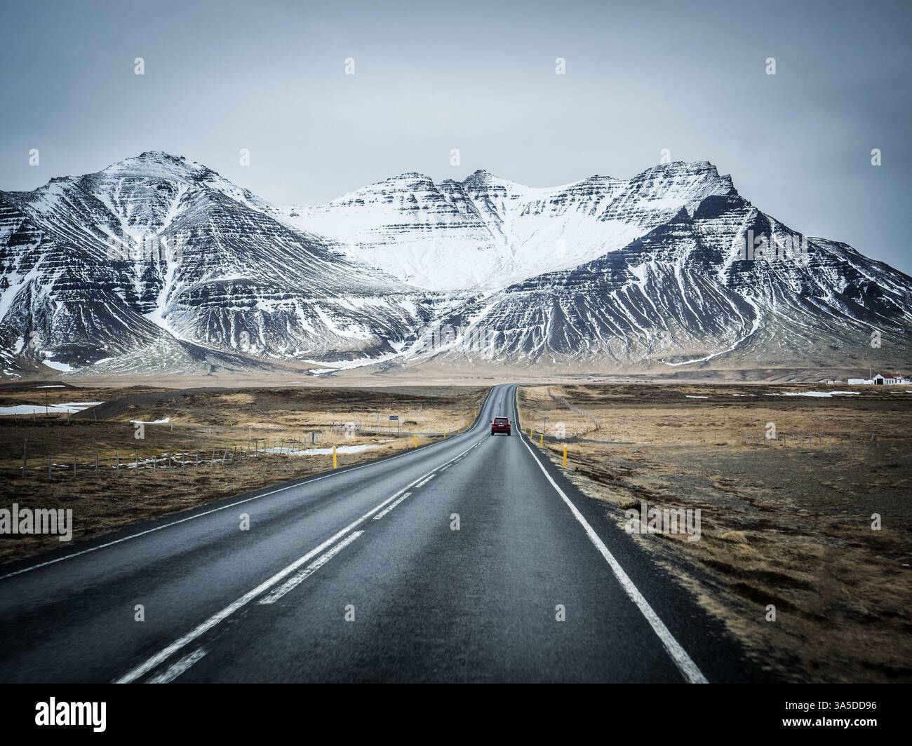 Modern car riding on asphalt countryside road towards magnificent snowy ...