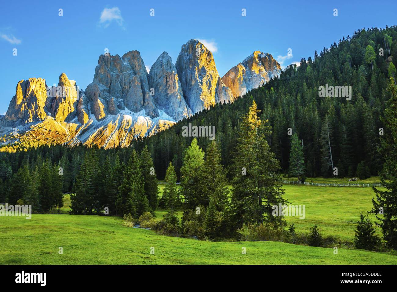 Magnificent serrated cliffs illuminate the summer sunset. The Dolomites ...