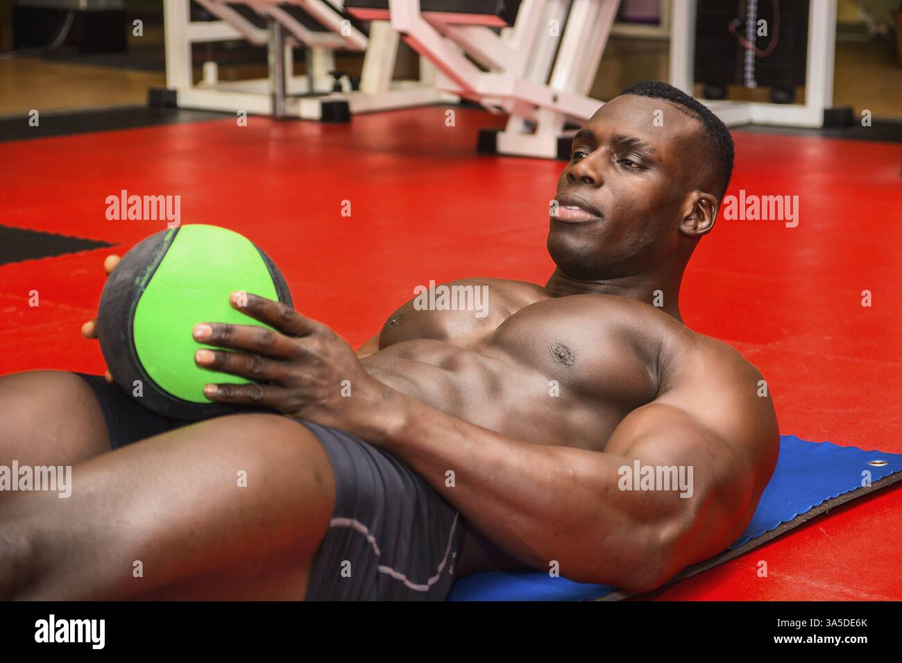 Hunky muscular black bodybuilder working out in gym, exercising abs ...