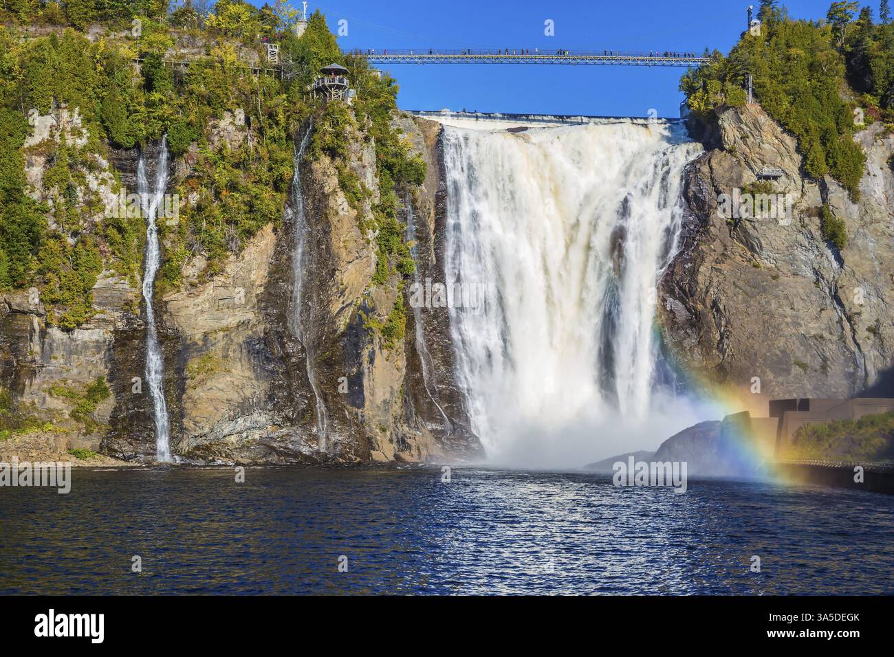 The magnificent rainbow plays in falls splashes. The blue lake and ...
