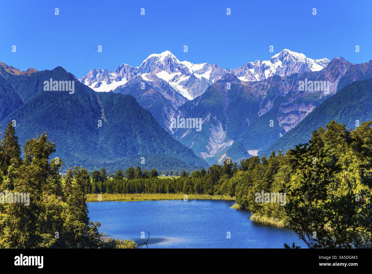 Magnificent snow-capped mountains are reflected in the smooth cold ...