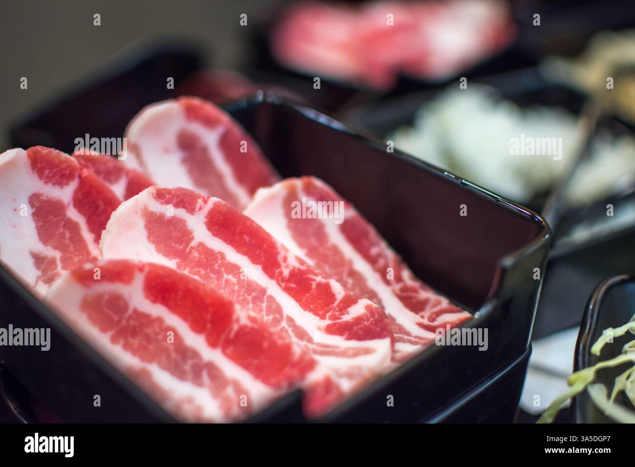 Pork raw meat slides on dish with barbecue sauce at BBQ. yakiniku grill ...