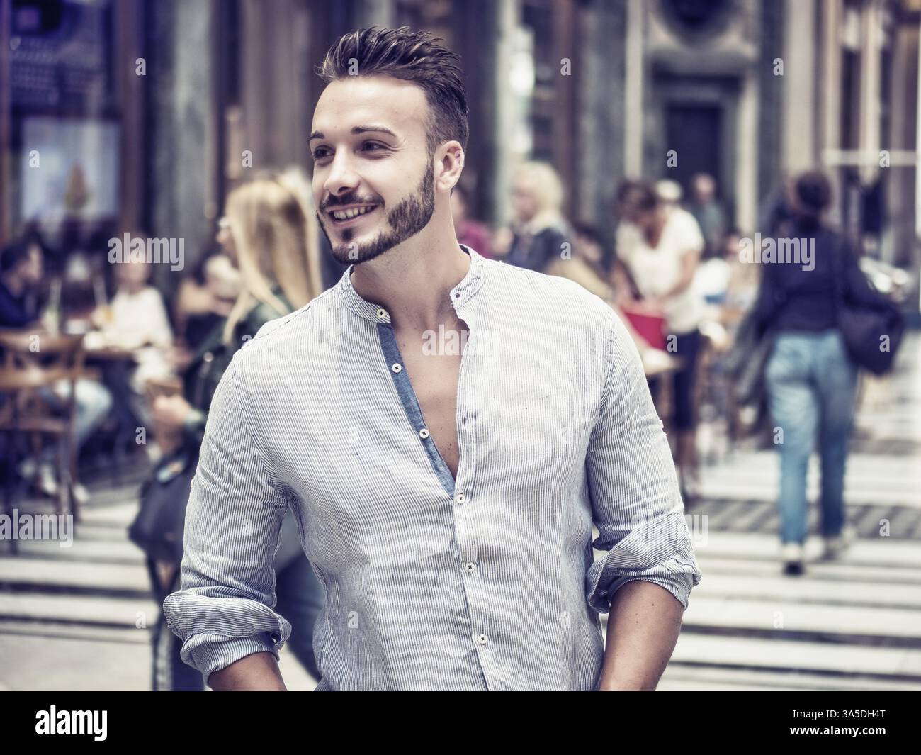 One handsome young man in urban setting in European city, standing ...