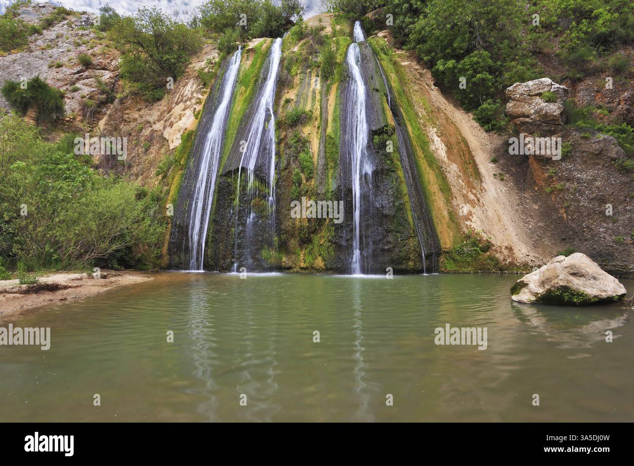 Three-jet scenic waterfall in the mountains. Three parallel streams of ...
