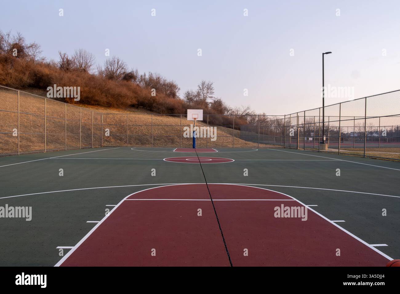 Basketball court with clear lines and a hoop surrounded by a quiet ...