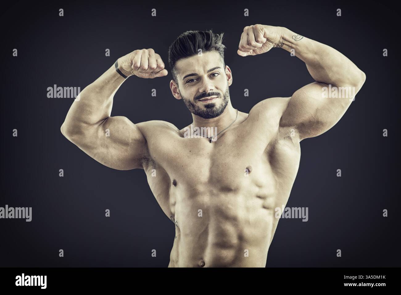 Handsome bodybuilder doing classic double biceps pose, looking away, on ...