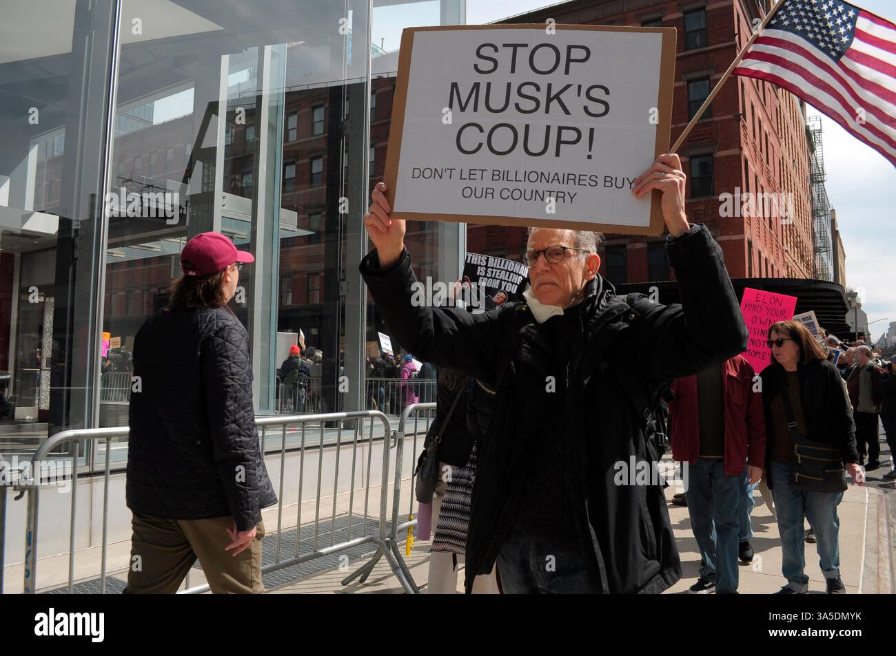 An anti-Elon Musk demonstrator holds a placard outside of a Tesla ...