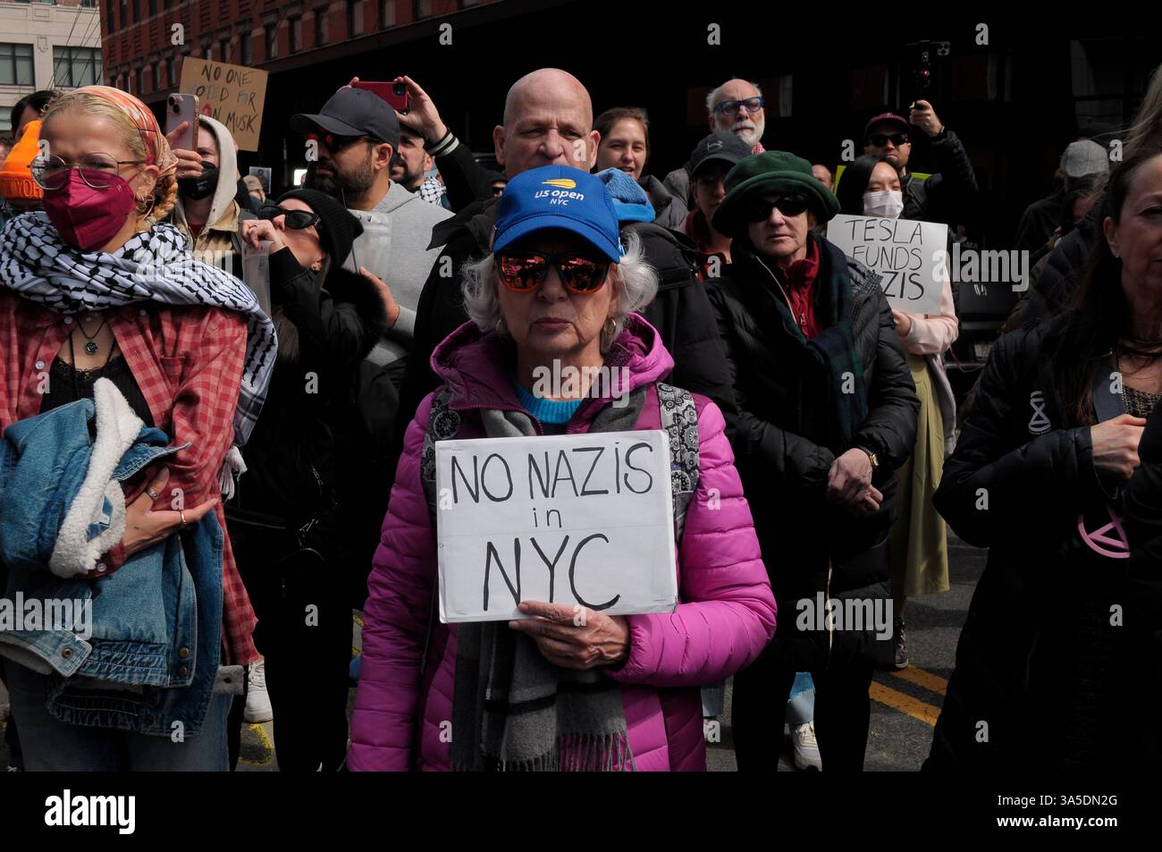 Anti-Elon Musk demonstrators hold placards outside of a Tesla showroom ...