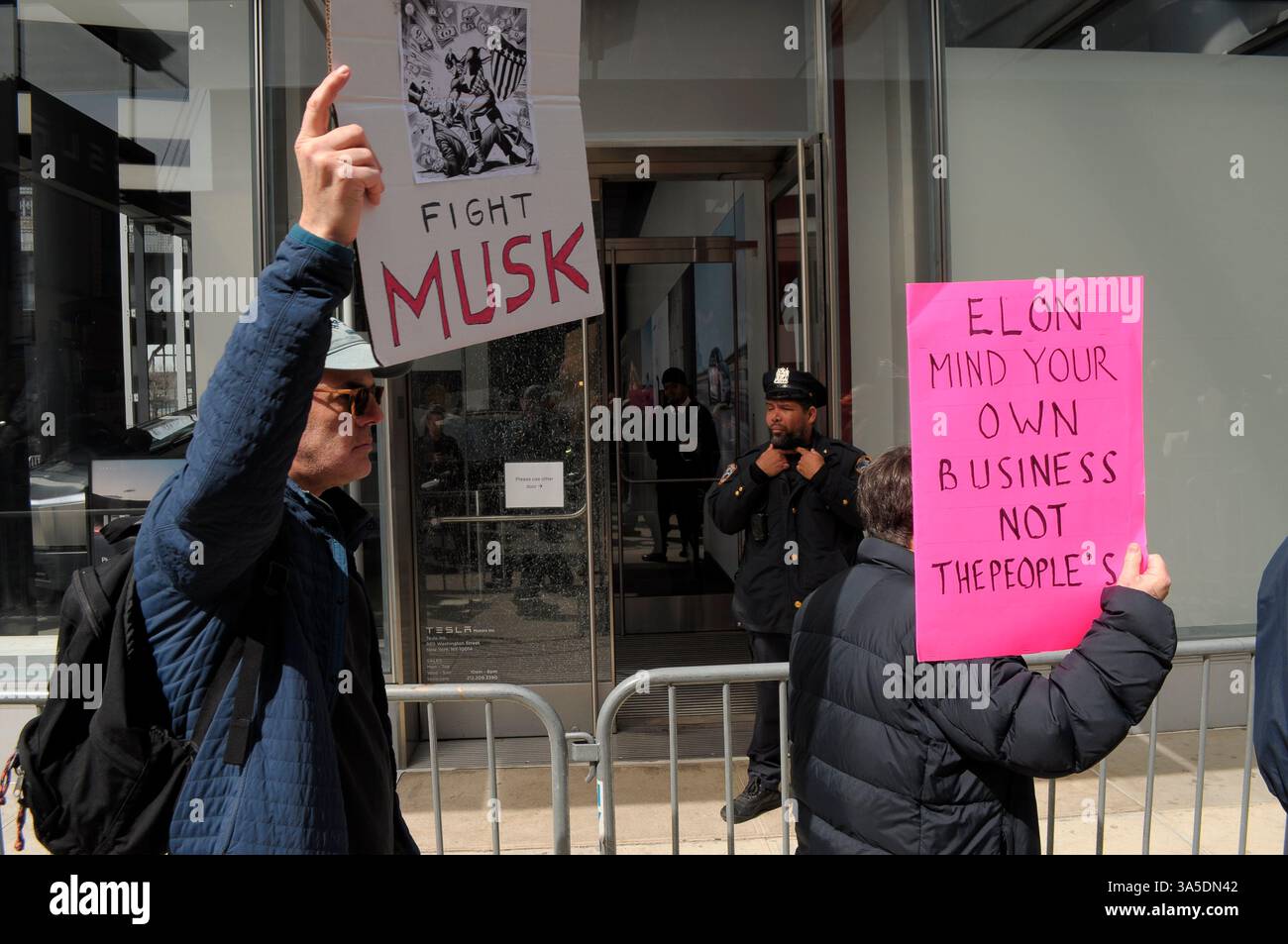 Anti-Elon Musk demonstrators hold placards outside of a Tesla showroom ...