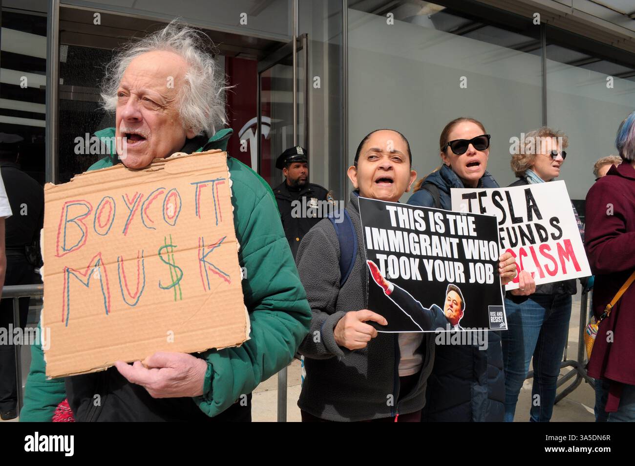 Anti-Elon Musk demonstrators hold placards outside of a Tesla showroom ...