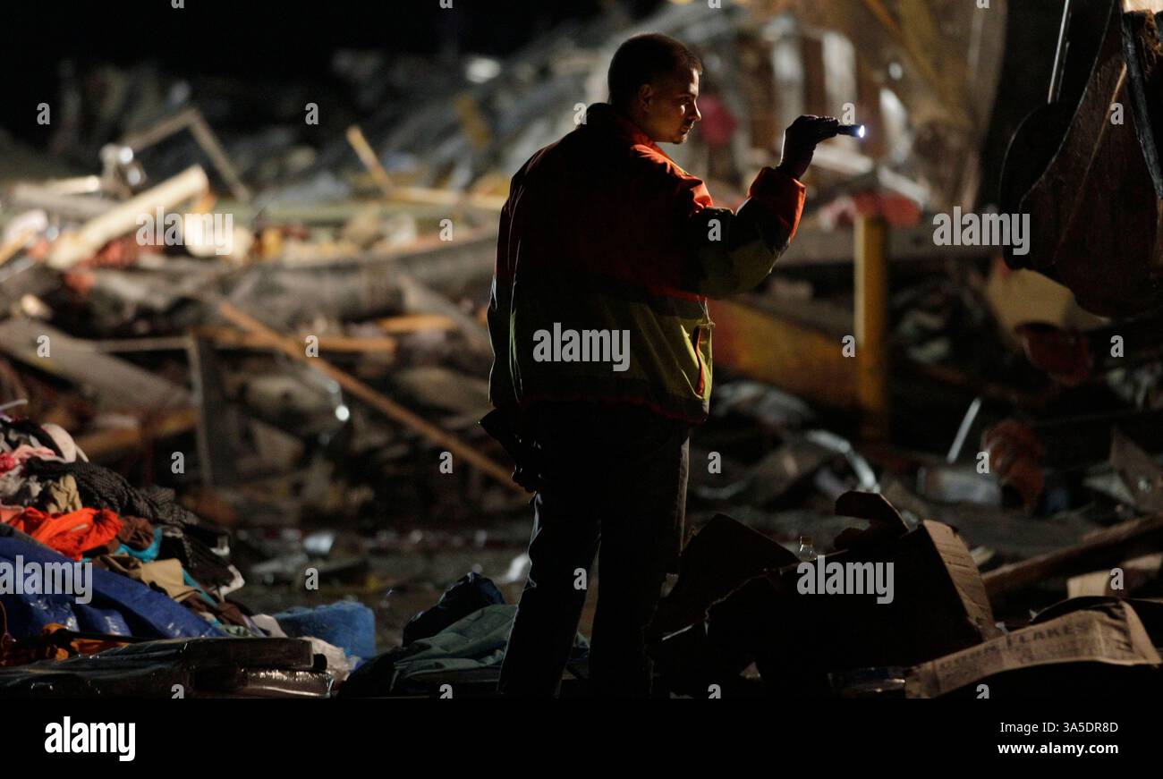 FILE- An emergency worker searches a Walmart store that was severely ...