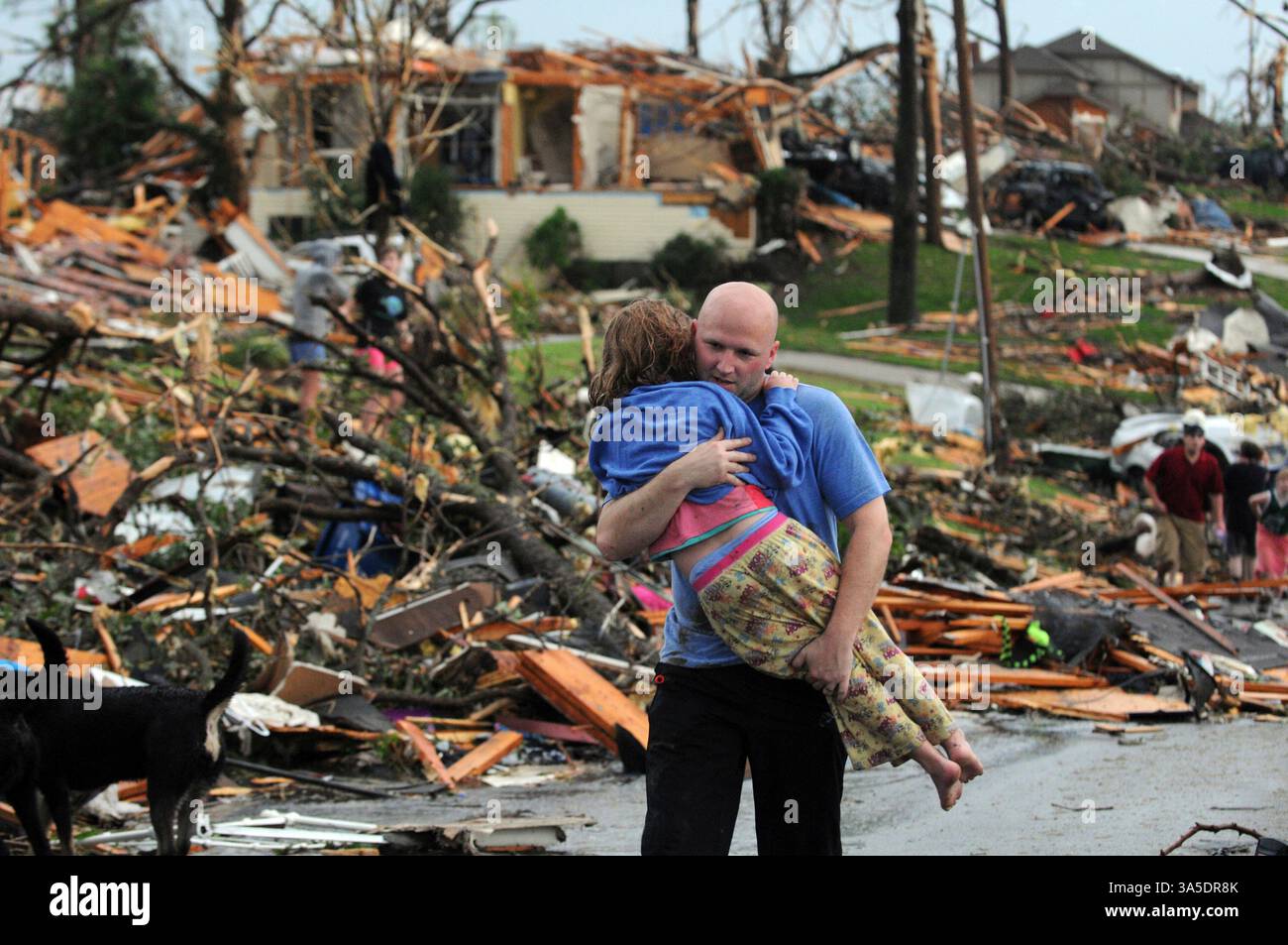 FILE- In this May 22, 2011 file photo, a man carries a young girl who ...