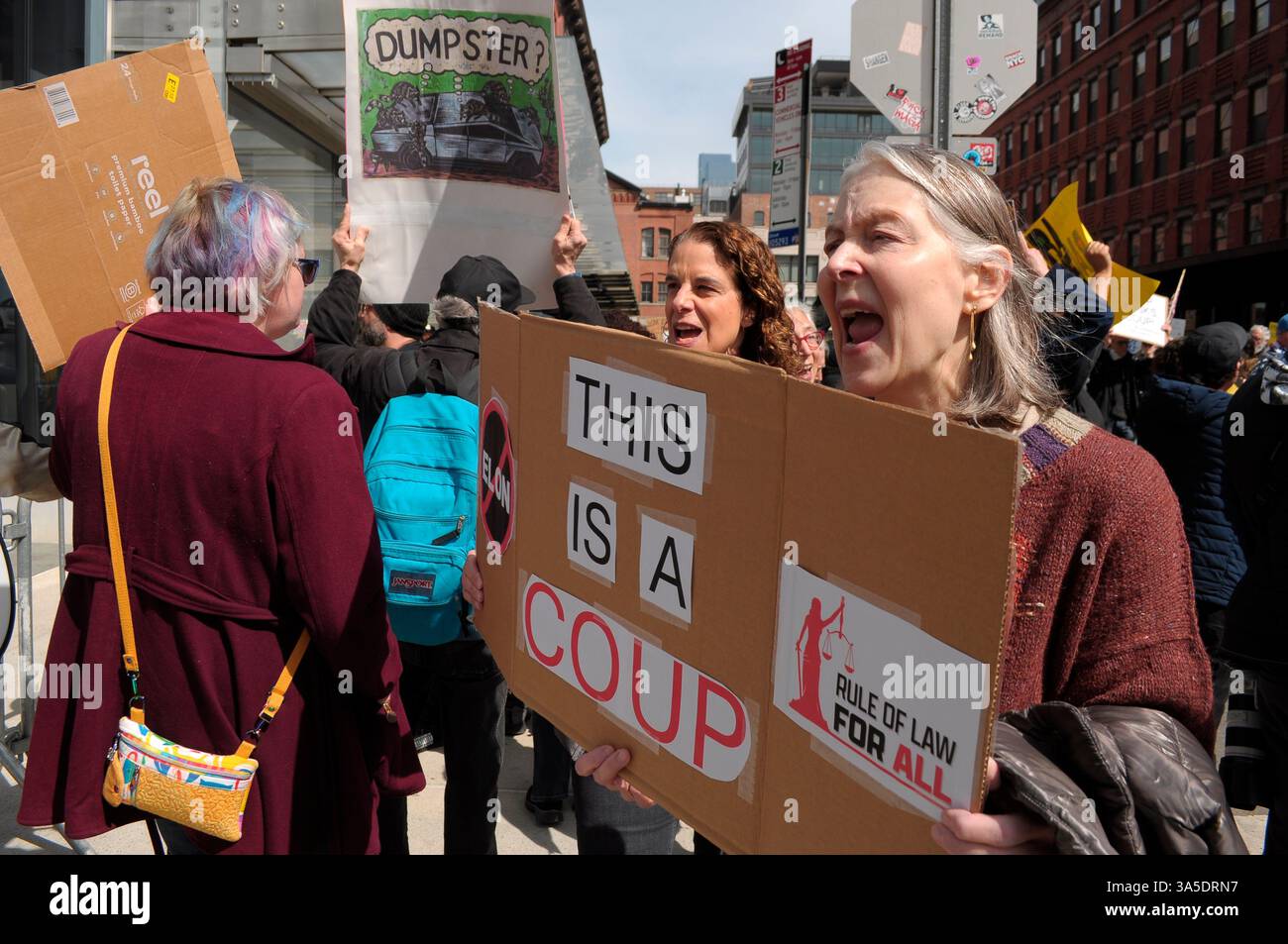 Anti-Elon Musk demonstrators hold placards outside of a Tesla showroom ...