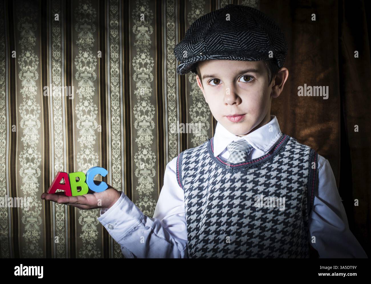 Child in vintage clothes hold multicolor letters a b c Stock Photo - Alamy