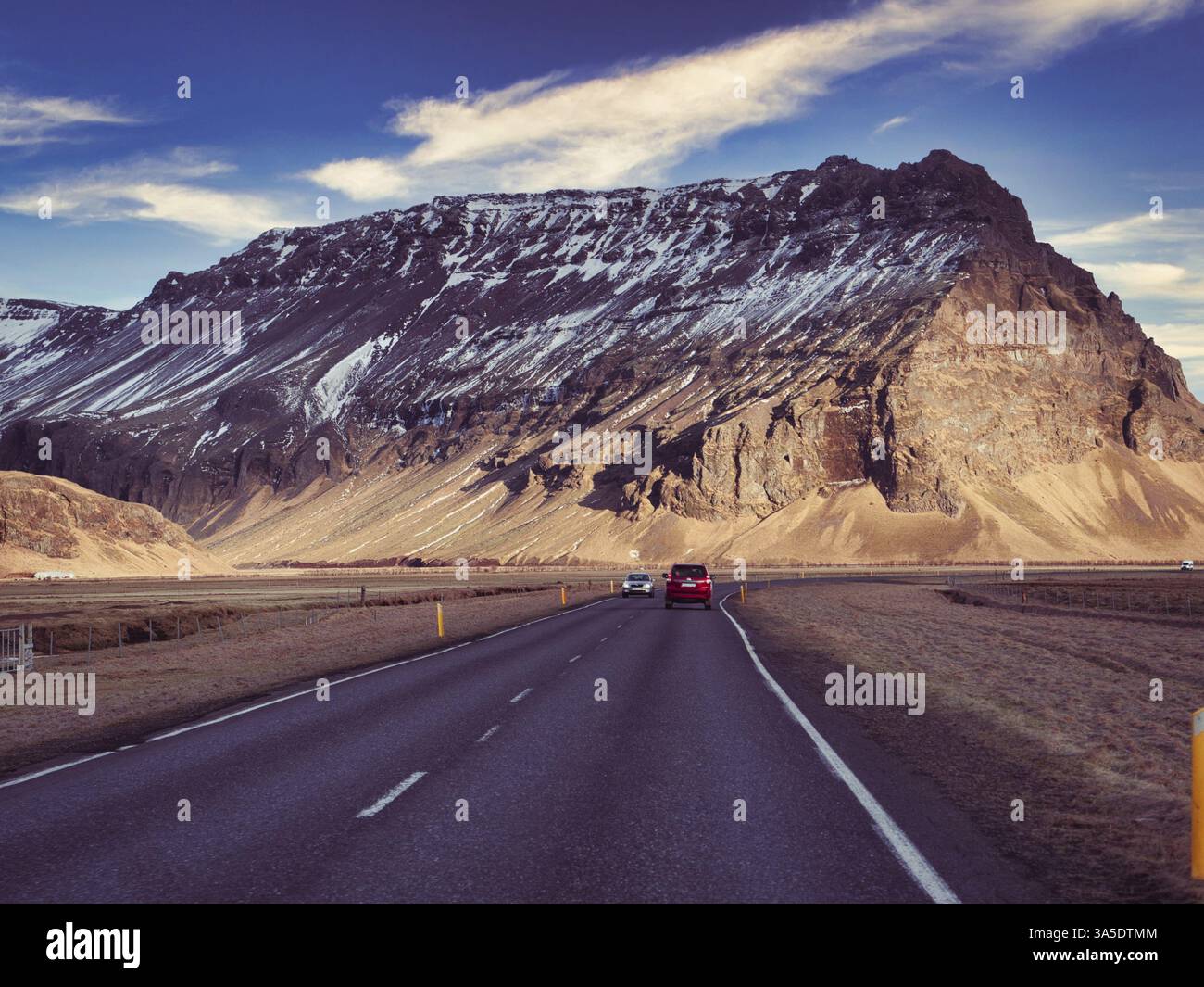 Modern car riding on asphalt countryside road towards magnificent snowy ...