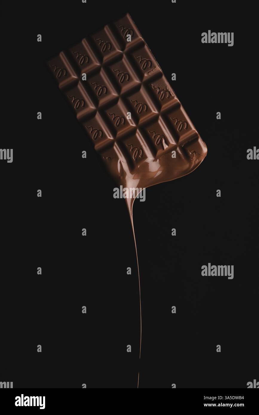A floating chocolate bar with melting drops on a black background Stock ...