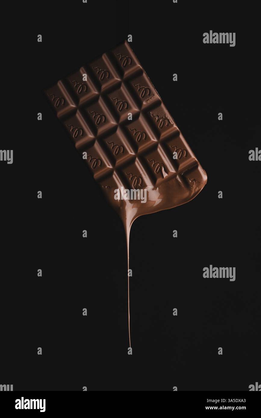 A floating chocolate bar with melting drops on a black background Stock ...