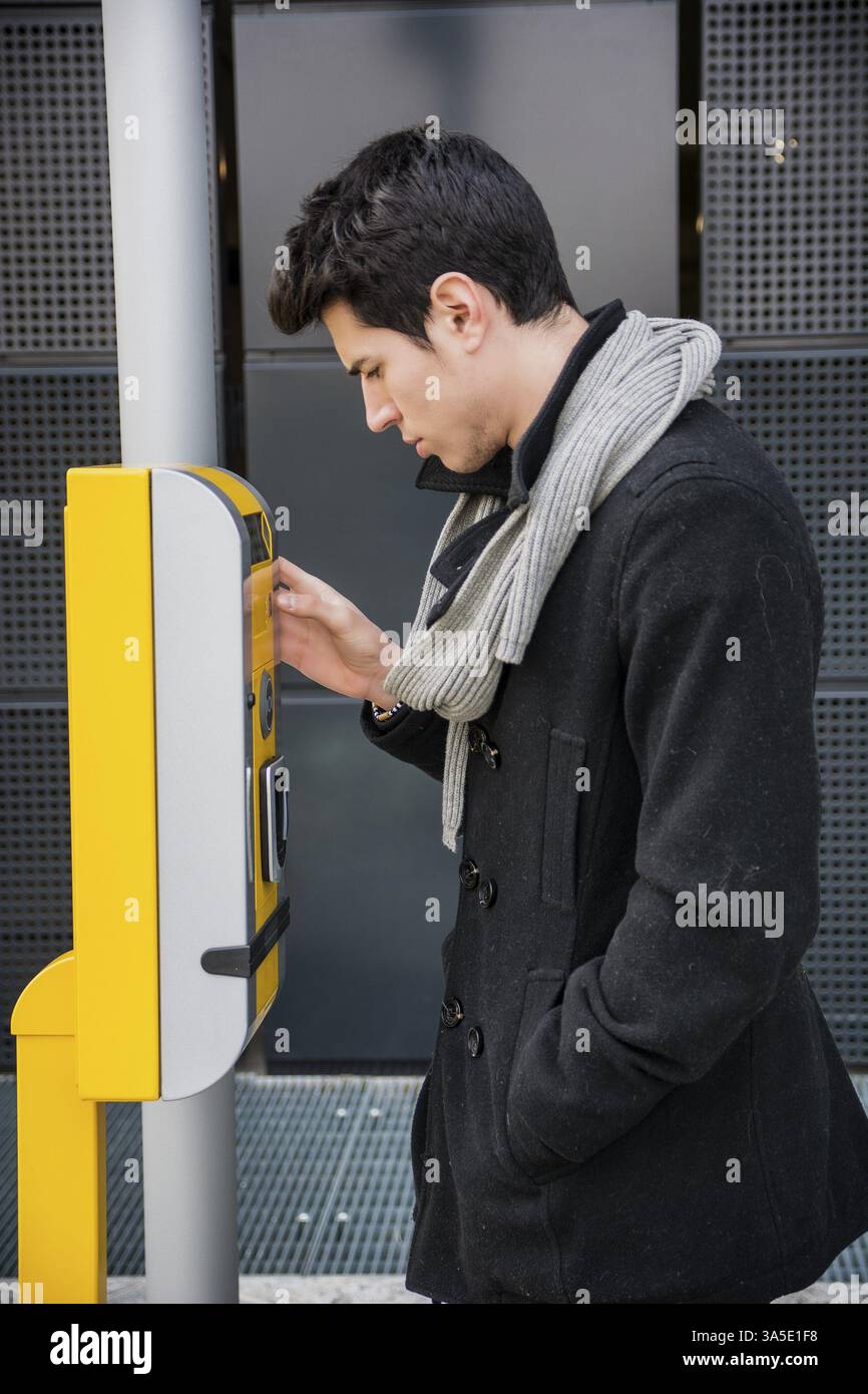 Handsome stylish young man bending down peering inside a glass entrance ...