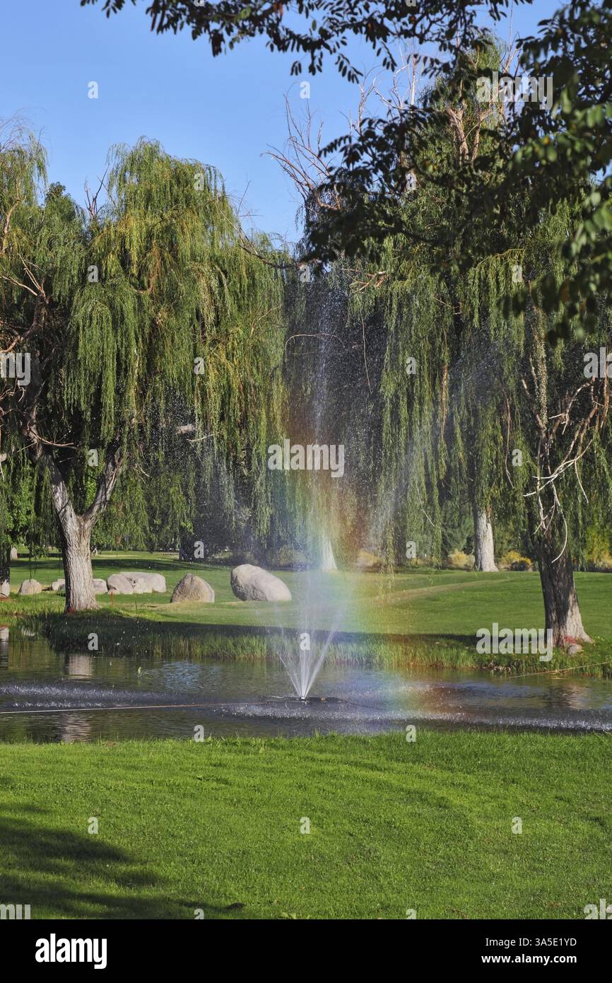 Decorative fountain and shining rainbow on the golf course Stock Photo ...