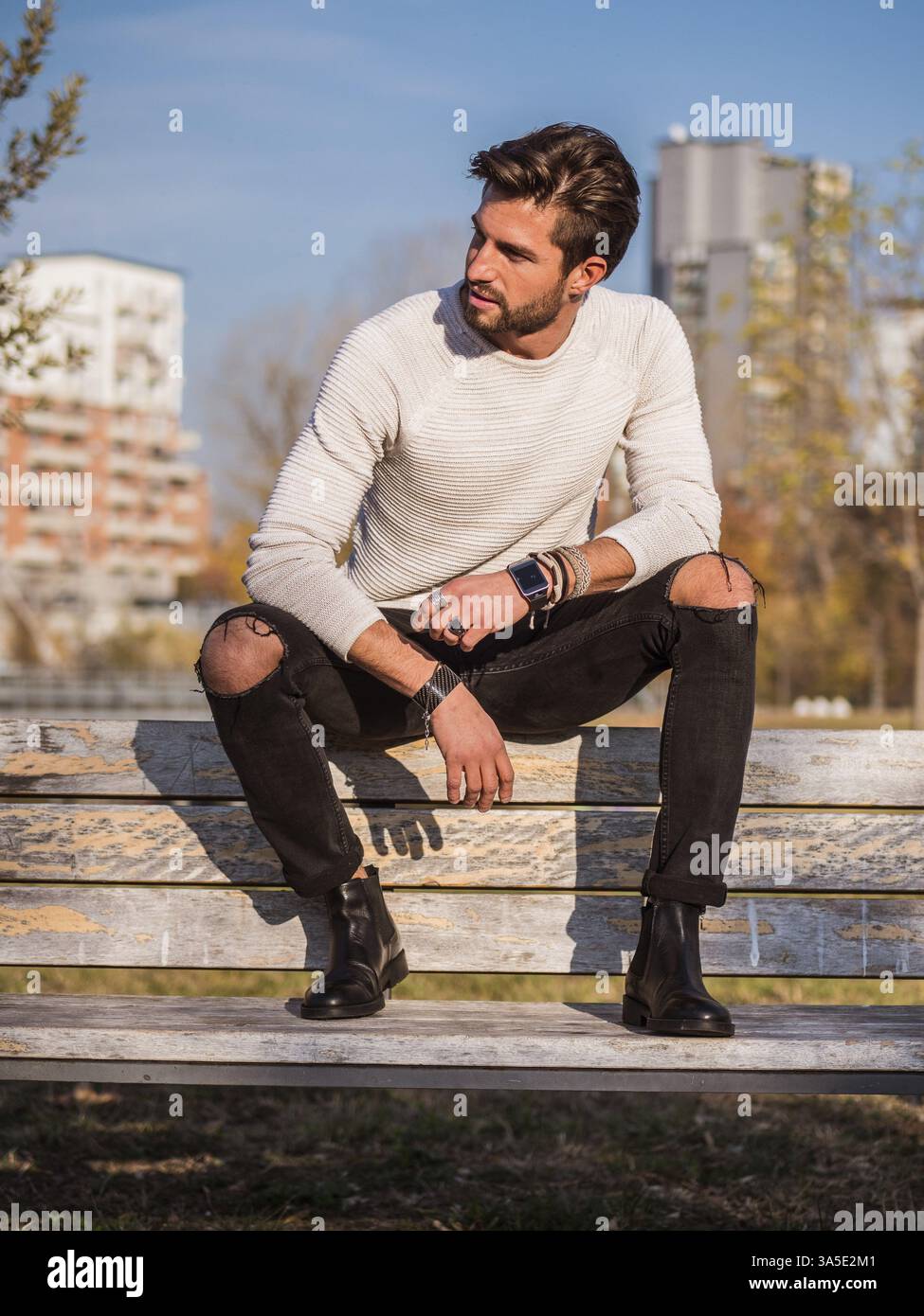One handsome man in urban park in European city, sitting Stock Photo ...