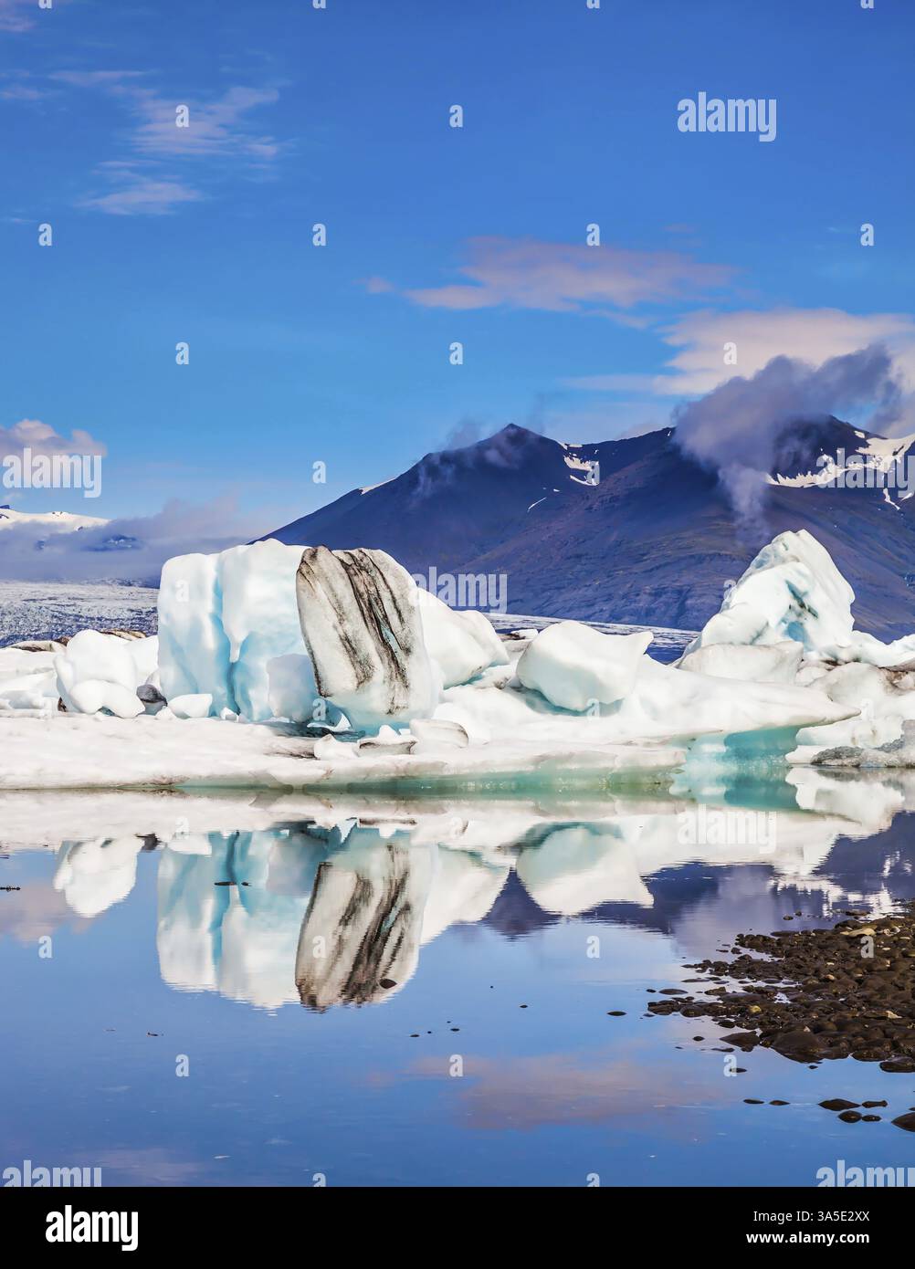 Icebergs and ice floes are reflected in the smooth water surface. Morning in the Ice Lagoon ...
