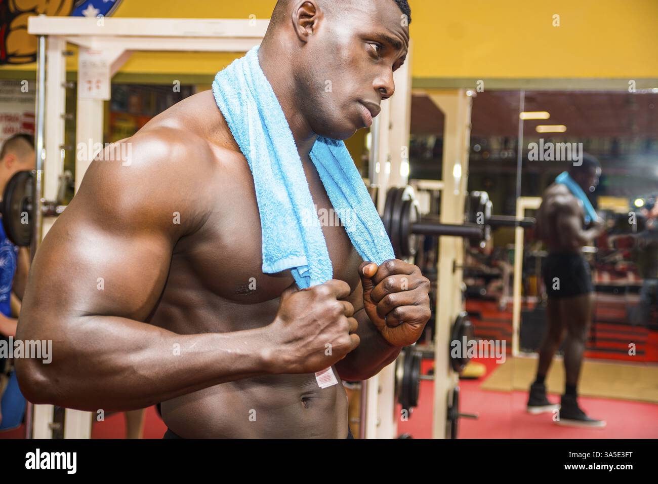 Hunky muscular black bodybuilder working out in gym, resting after ...