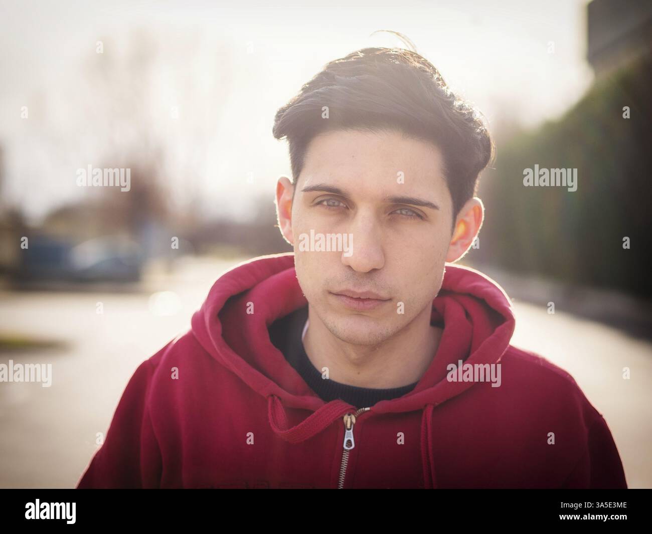 Headshot of one handsome young man with green eyes in urban setting ...