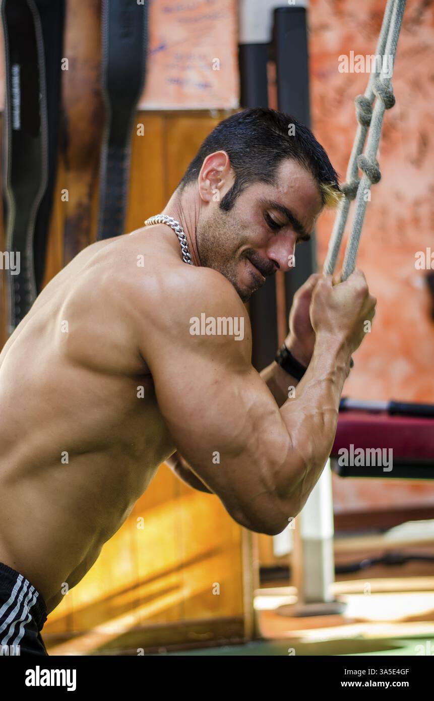 Man working out at the gym, side view of muscular and ripped chest, pecs and arm muscles Stock ...